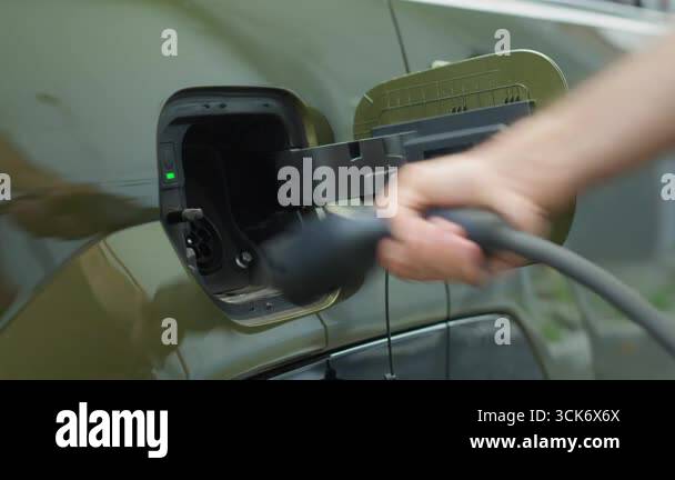 Eco friendly driver closing battery charging port flap of electric car ...