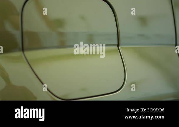 Extreme close up of driver opening charging port flap, plugging ...