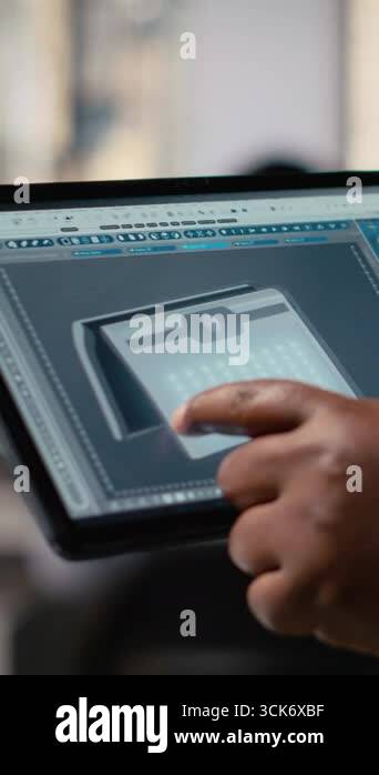 Close up of technician using tablet to create solar powered device ...