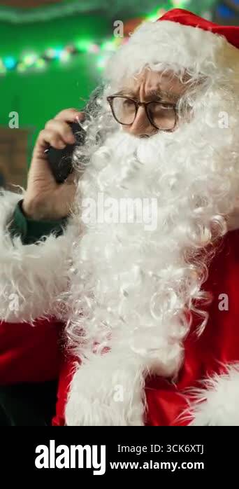 Vertical video Friendly Santa Claus performer talks with families on ...