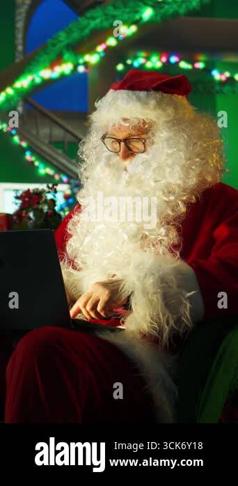 Vertical video Portrait of smiling man dressed as Santa Claus bringing ...