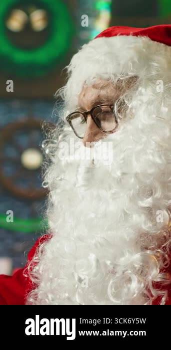 Vertical video Tired Santa Claus napping on chair while reading letters ...