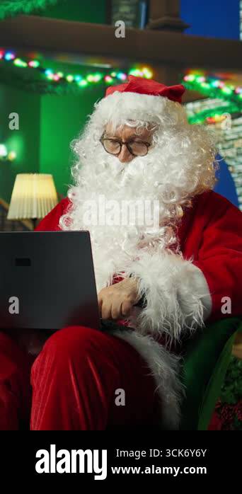 Vertical video Smiling man dressed as Santa Claus looking at letter ...