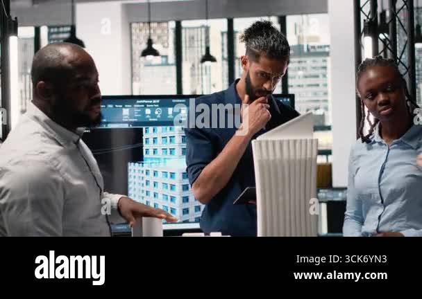 Contractors and engineers reviewing 3D models and construction blueprints with strategic ...