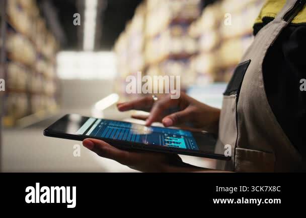Close up of distribution hub worker overseeing supply chain process for ...