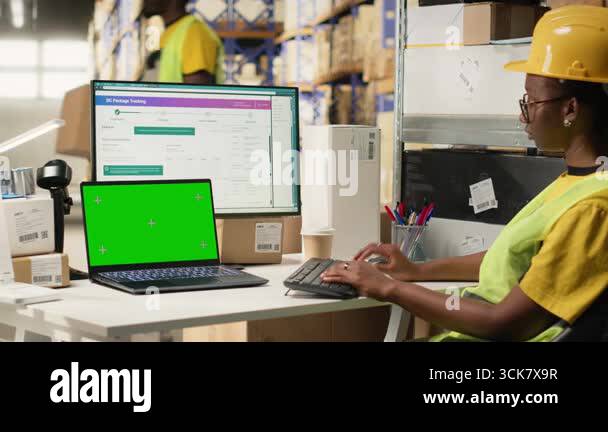 Female warehouse clerk checking awb labels next to chroma key on screen, working in depot with ...
