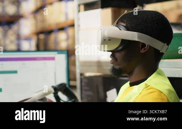Black warehouse clerk uses virtual reality headset for online shopping ...