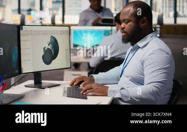 Technician using CAD program on PC to optimize wind turbine design ...