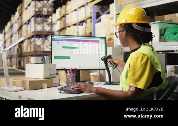 Black warehouse assistant register tracking info on tags with scanner ...