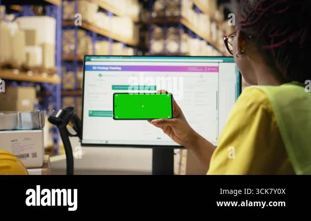 Black woman holds phone with chroma key and monitors parcel shipment on ...