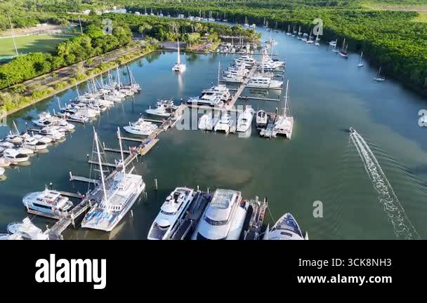 Drone footage captures boats in a tropical marina surrounded by lush ...