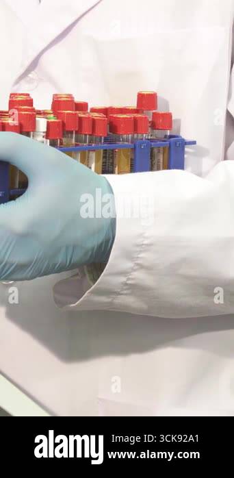 A dedicated male lab technician, clad in a crisp white coat and blue ...