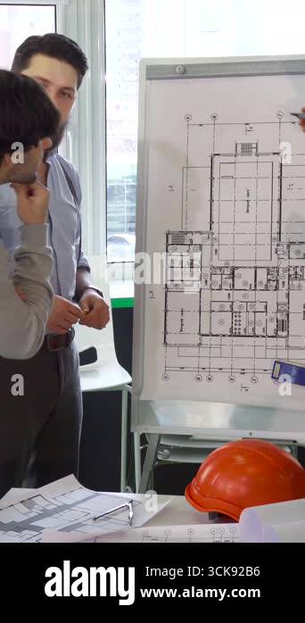 An attractive young male architect enthusiastically gestures towards a ...