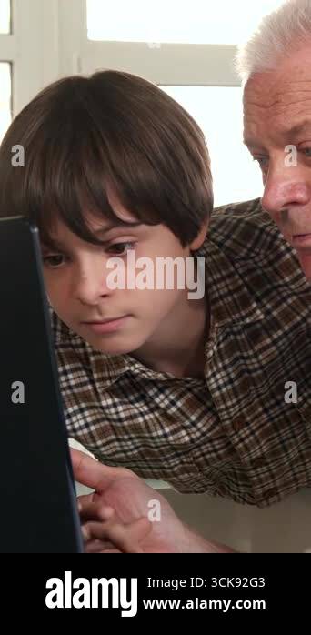 In this heartwarming scene, a little brunette boy attentively assists ...