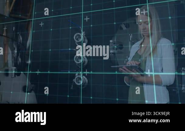 Technician tapping tablet screen in workshop and activating AR grid ...