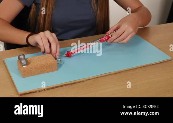 A person uses a spring scale to measure frictional force on a block ...