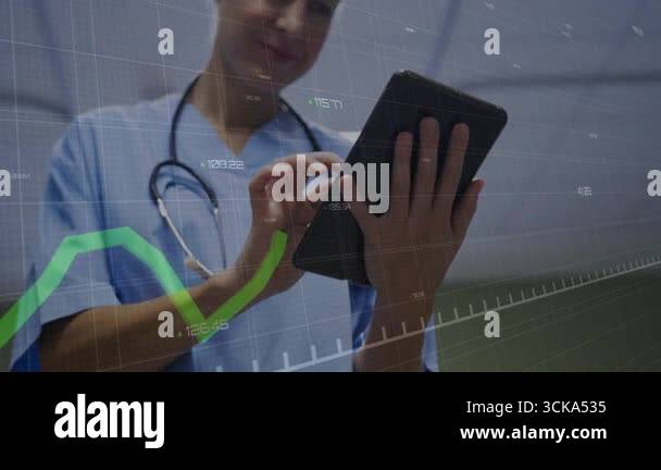 Mid adult female nurse raising tablet tapping screen analyzing data ...