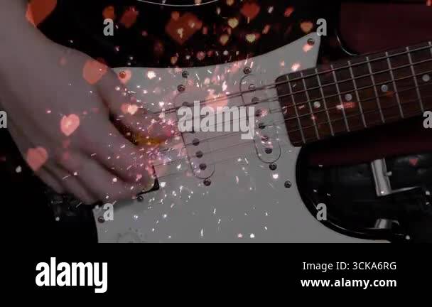 Musician playing guitar in studio, plucking strings causing heart ...