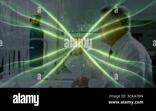 Senior scientist typing at lab bench generating glowing green particle ...