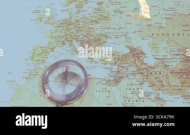 Hand entering left rotating compass to align needle north for ...