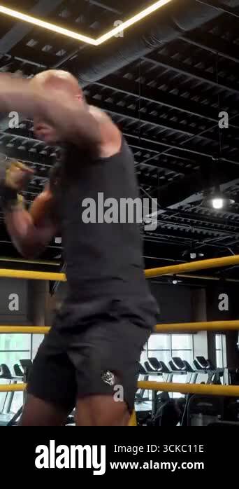 An intense African male boxer is captured mid-motion, shadow boxing ...