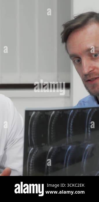 In a sleek, modern clinic, two dedicated male doctors are deeply ...
