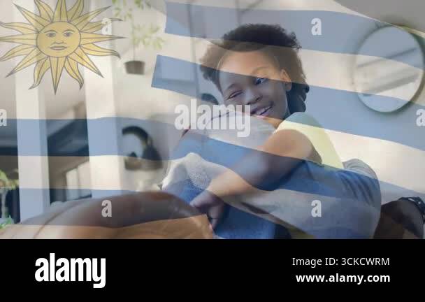 Girl walking toward father on sofa, initiating family hug and rocking ...