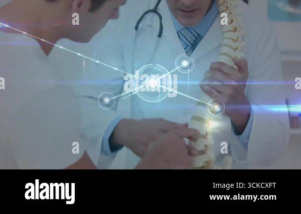 Doctor entering with spine model explaining lumbar area with network ...