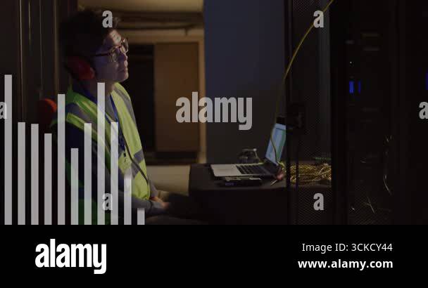 Technician monitoring rising bar graph in data center, typing server ...