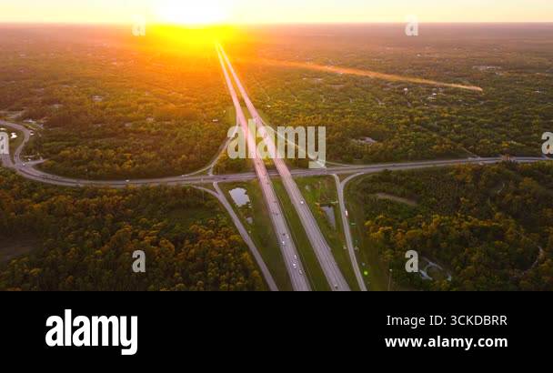 Sunset light over elevated rural freeway junction with long haul trucks ...