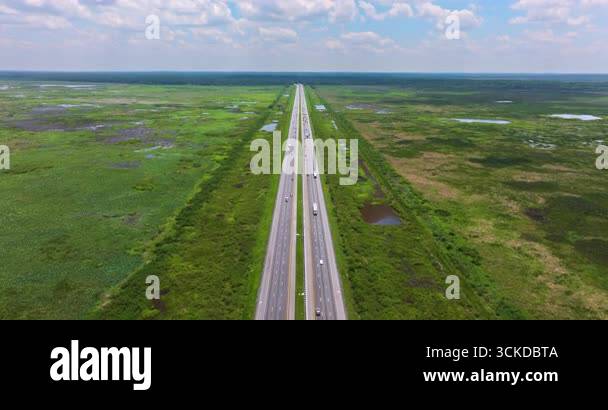 Aerial view of Florida highway slicing through natural wetland terrain ...