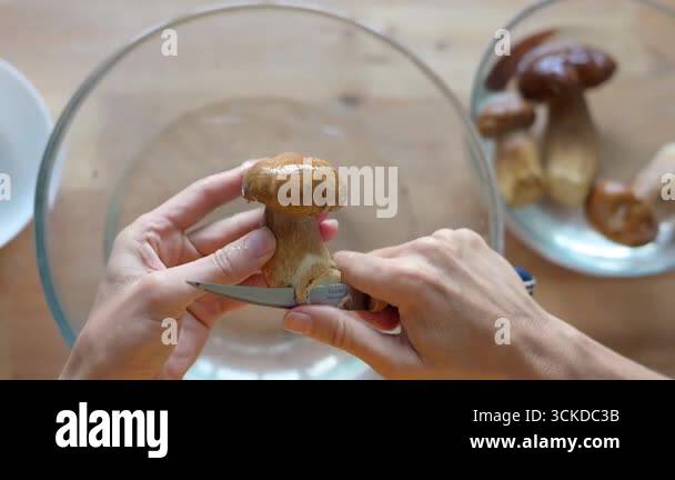 Chef carefully cleaning wild porcini mushroom using knife over water ...