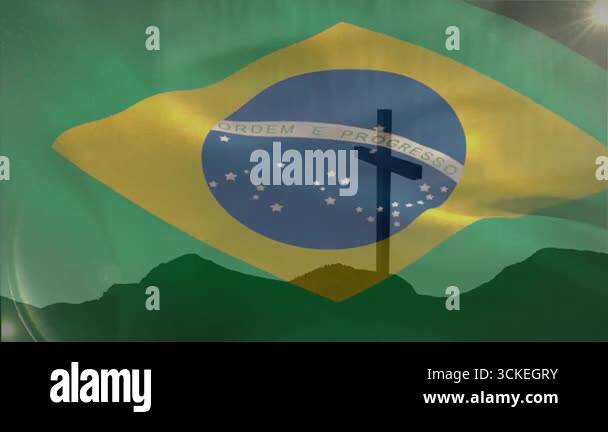 Brazilian flag catching breeze and rippling over mountain cross ...