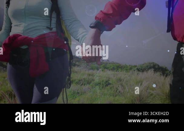 hiking couple holding hands across hill, starting drifting tech overlays visualizing trail data ...