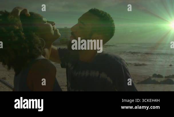 Man brushing hair back couple sharing kiss on rocky oceanfront at ...