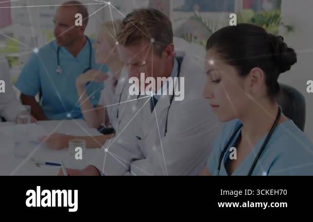 Doctor leaning and speaking to team, guiding patient file review with ...