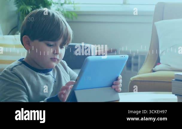 Boy tapping blue tablet on coffee table in living room while animated ...