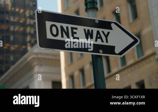 Iconic black and white ONE WAY street sign on a metal pole in a U.S ...