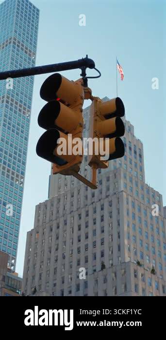 Yellow traffic light hanging above Manhattan street with tall ...