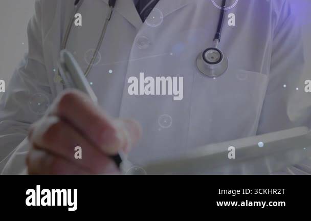 Male doctor using stylus and analyzing patient data on tablet ...