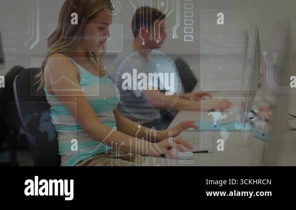 Coworkers typing on desktops activating technology interface with code overlays for data insight ...