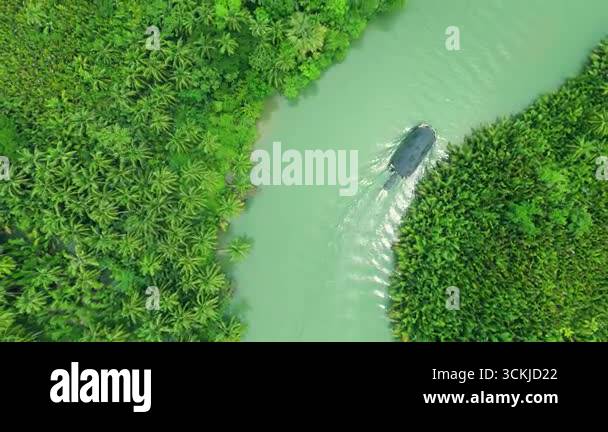 Aerial view of a boat navigating the green Yavari River, surrounded by ...