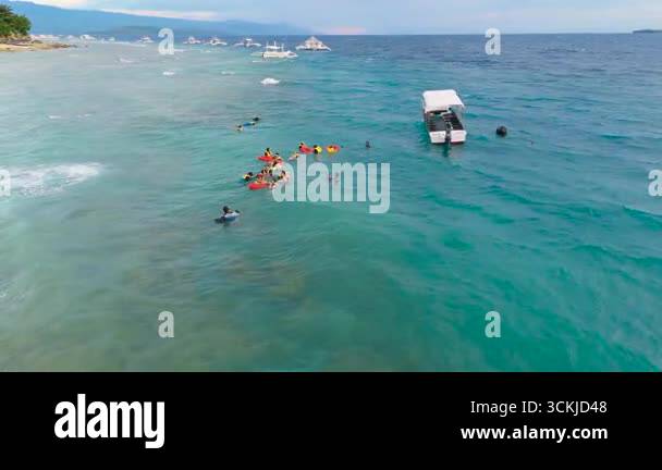 Aerial view of a group of people swimming and snorkeling near a boat ...