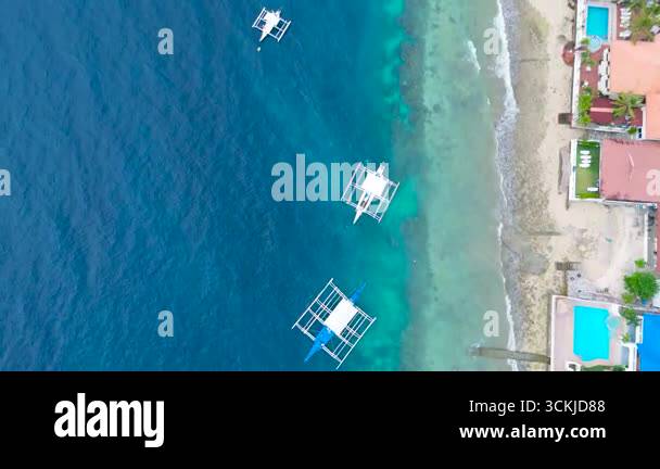 Aerial view of traditional outrigger boats floating on turquoise ocean ...