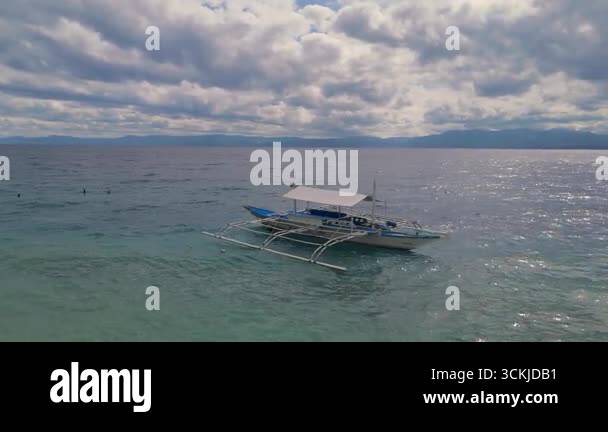 Traditional Filipino outrigger boat bangka on clear turquoise water ...