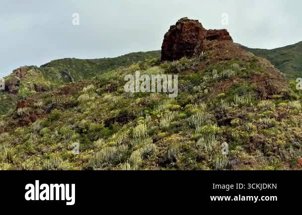 A breathtaking view of vibrant green hills with a striking rock ...