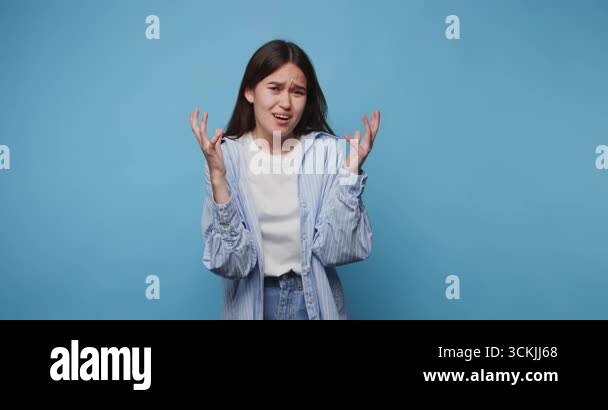 footage of young woman shows a frustrated expression, hands raised ...