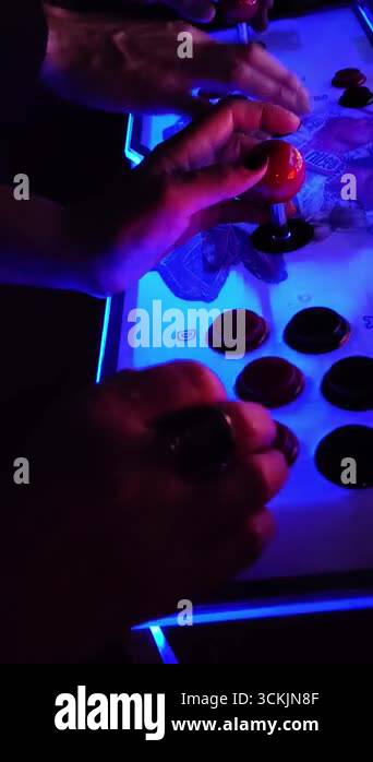 High angle close up on peoples hands playing a vintage arcade video ...
