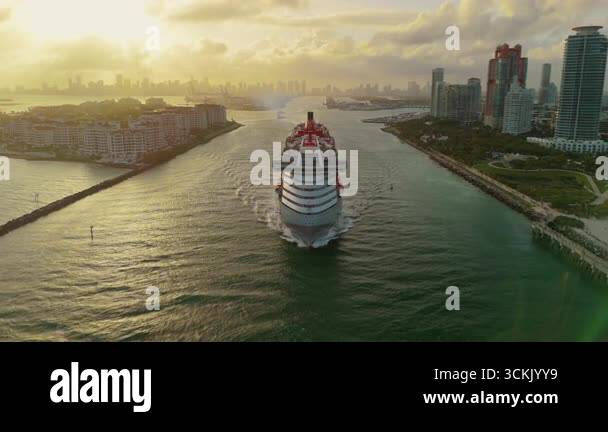 The large cruise liner slowly departing from Miami harbor with the gold ...