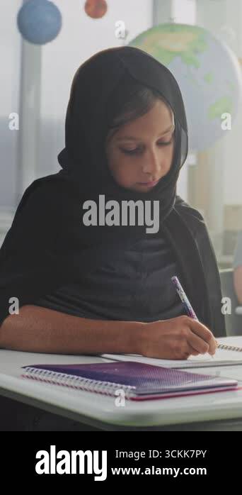 Young Muslim Girl Wearing Hijab Sitting at the Desk, Writing School ...